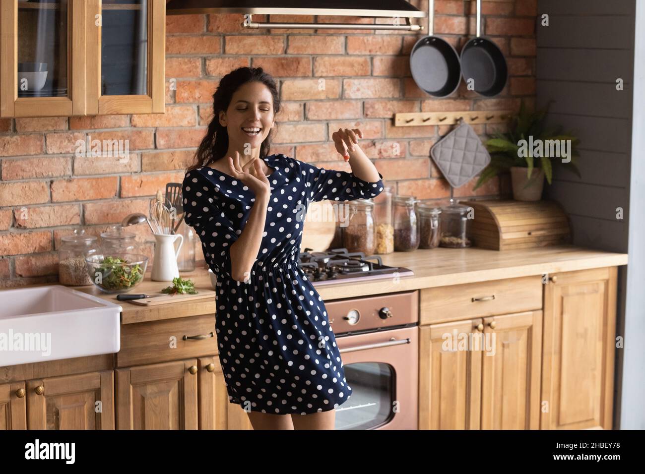 Happy energetic young woman dancing in kitchen Stock Photo - Alamy