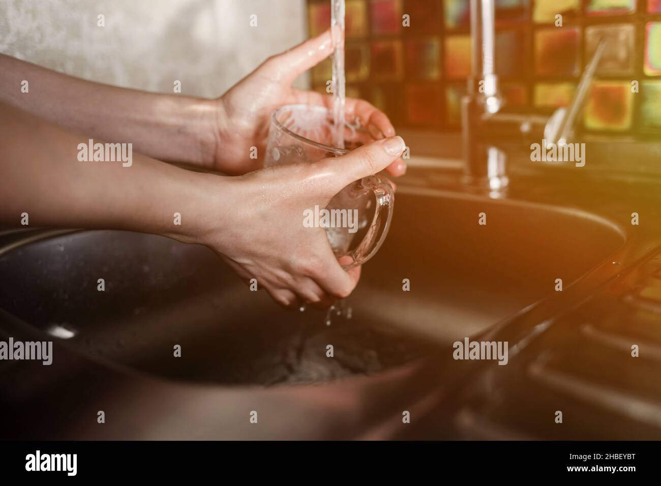 homework - close-up of women's hands washing a cup under a stream of ...