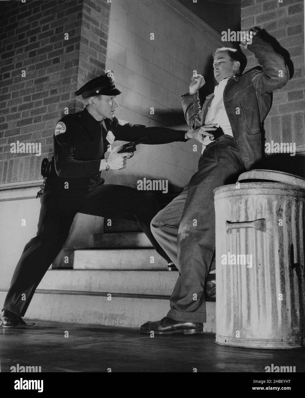 Policeman in alleyway with gun drawn on male suspect with a gun in ...