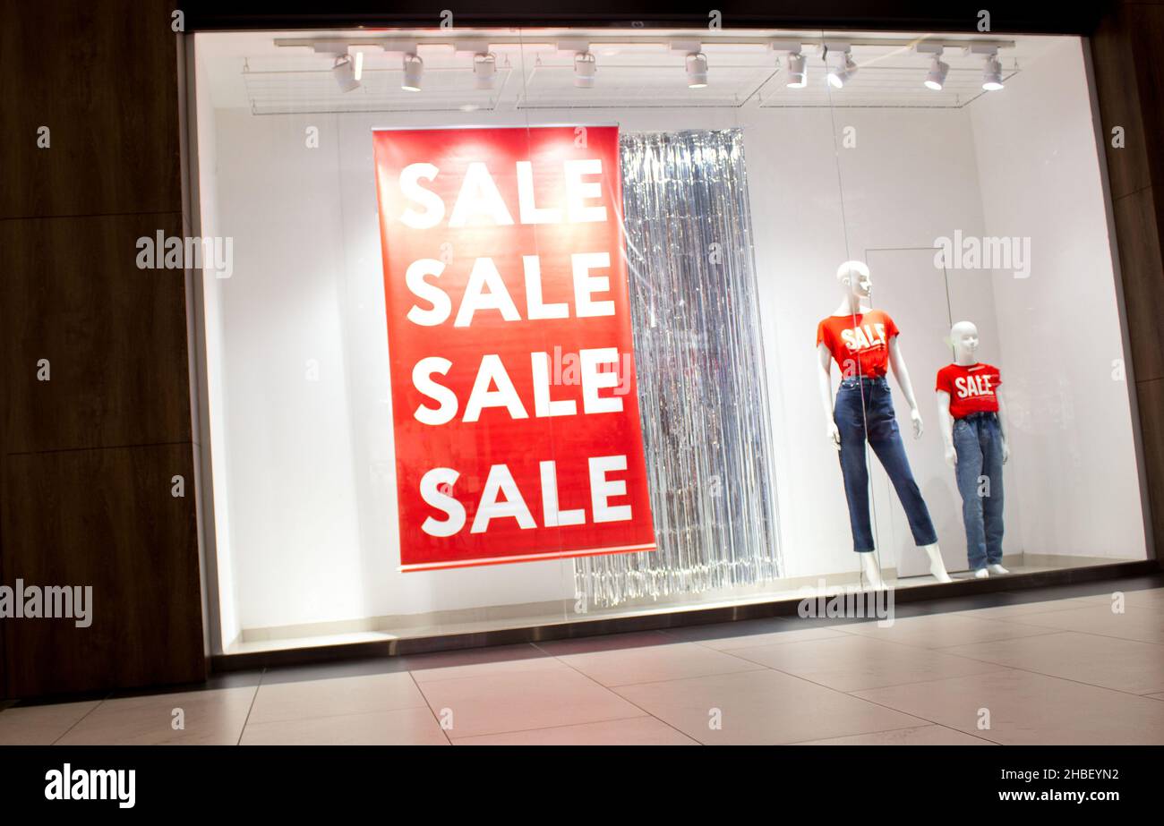 Shop window with discount and sale sign and mannequins Stock Photo - Alamy