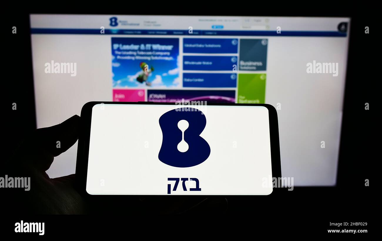 Person holding cellphone with logo of Bezeq The Israeli ...