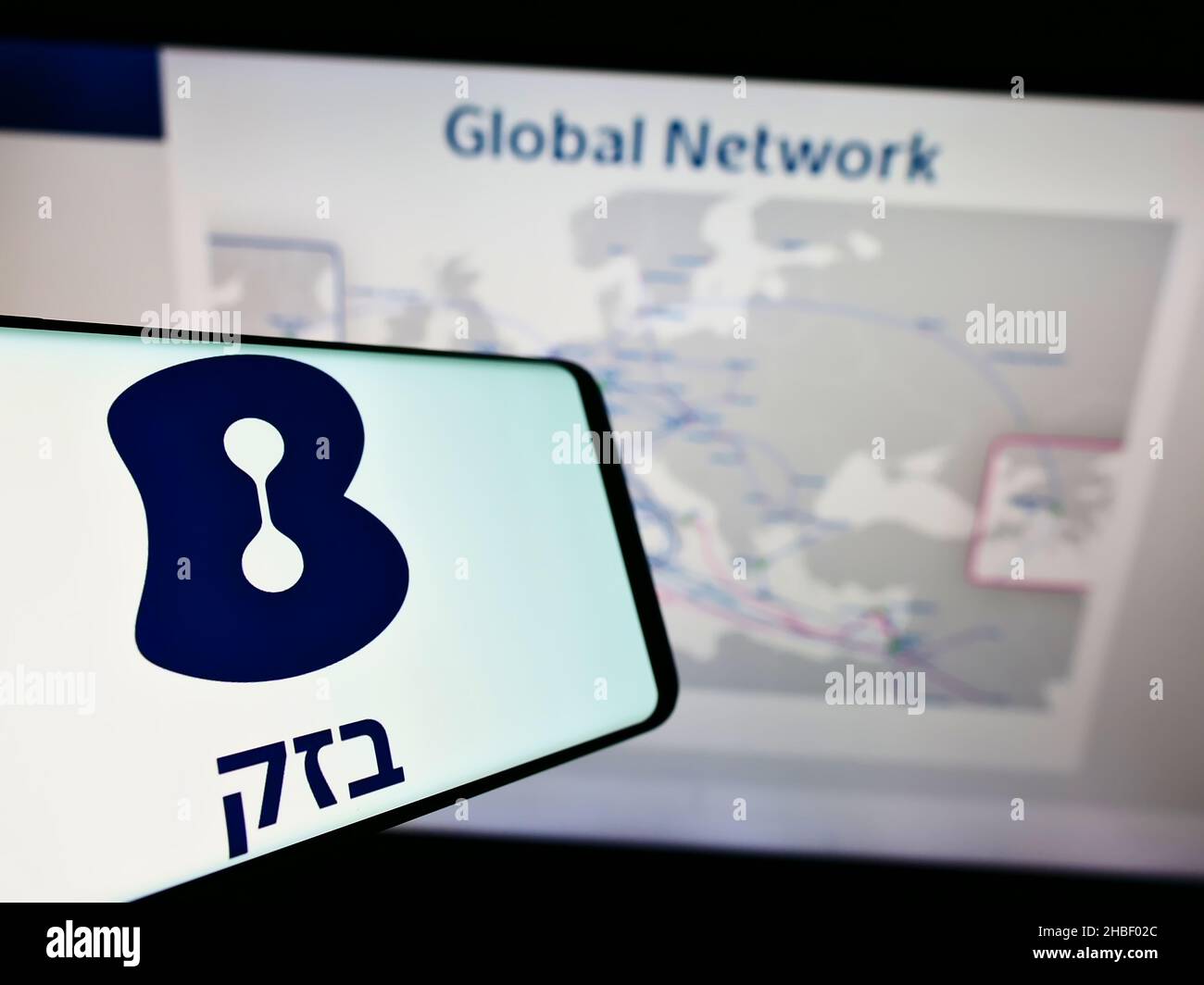 Mobile phone with logo of Bezeq The Israeli Telecommunication Corp Ltd ...