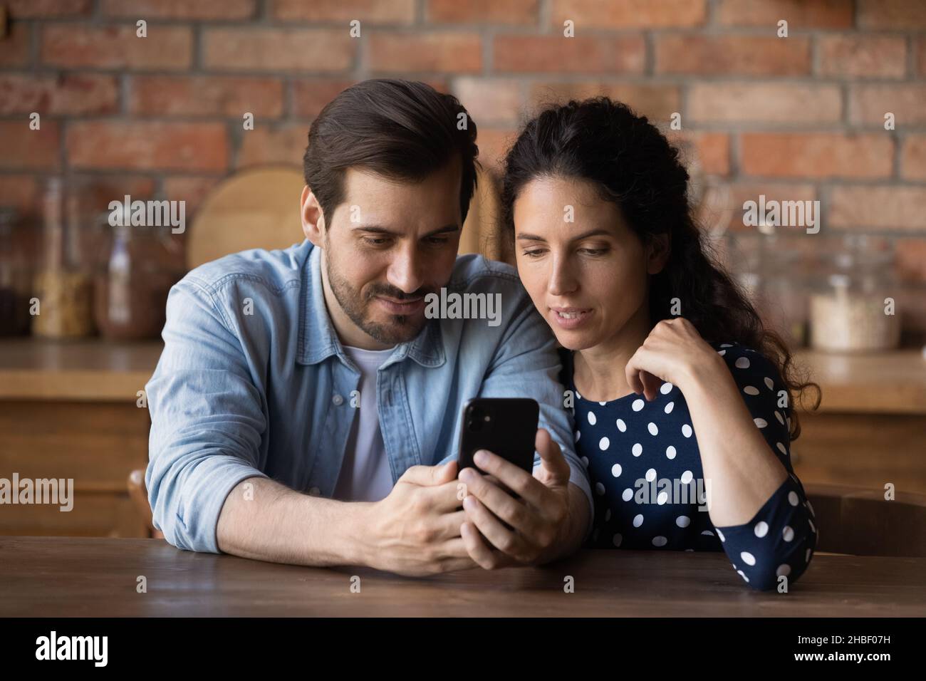 Happy bonding family couple using smartphone at home Stock Photo - Alamy