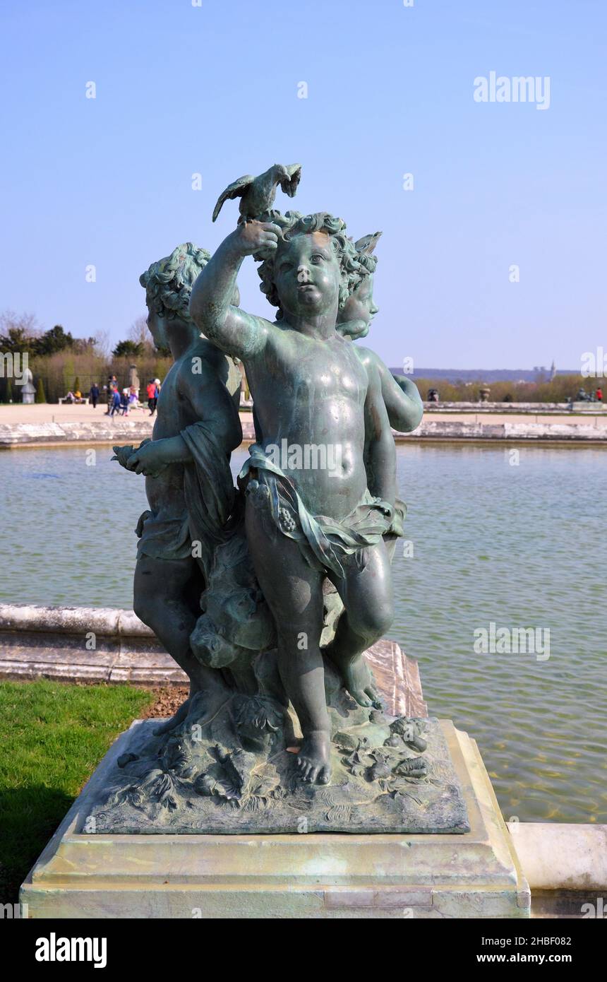 Bronze statue of three cherubs on the edge of a basin of the Bassin du ...