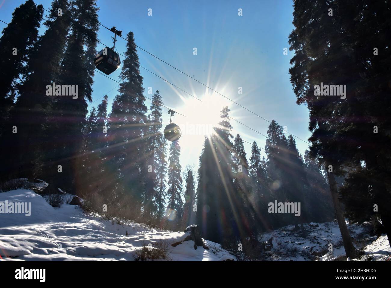Gulmarg, India. 19th Dec, 2021. Cable cars move above snow capped peaks ...