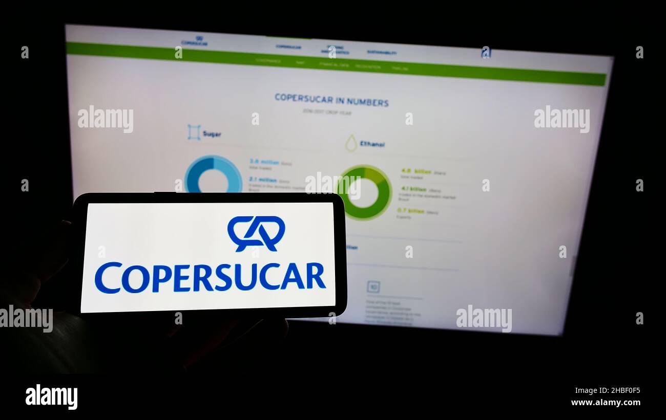 Person holding mobile phone with logo of Brazilian sugar and ethanol ...