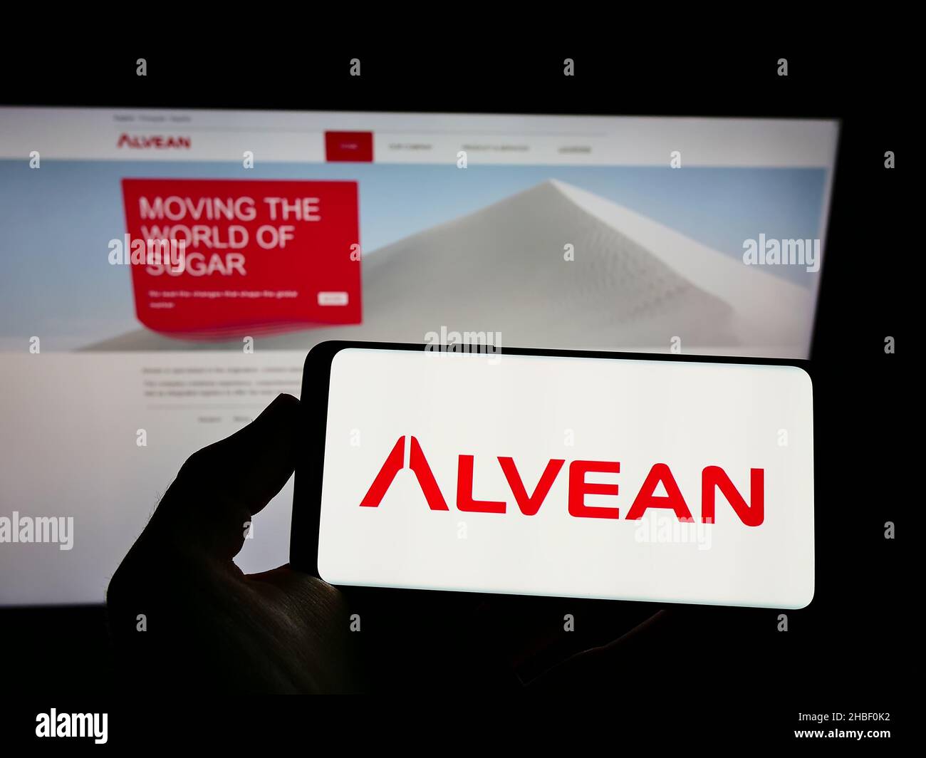 Person holding smartphone with logo of sugar trading company Alvean ...