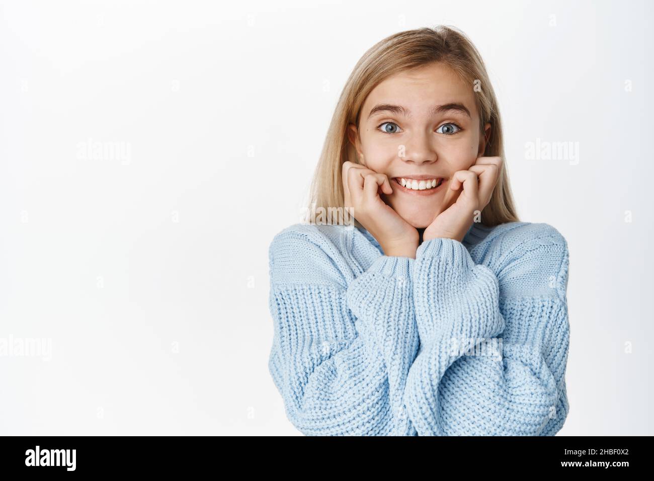 Close up portrait of enthusiastic little blond girl, looking with ...