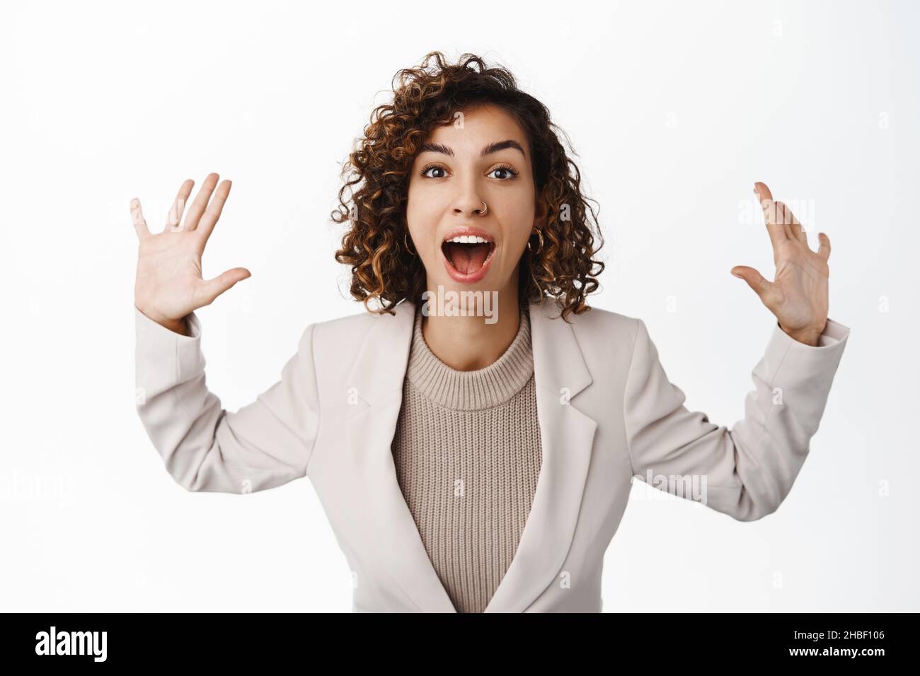 Beautiful young businesswoman flying, shouting with raised hands up and ...