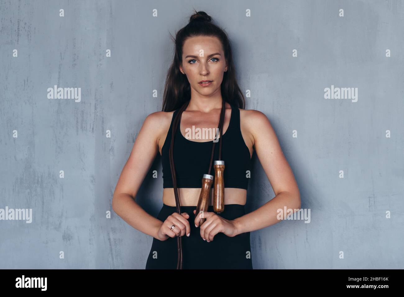 Sporty woman with a jump rope looks at the camera Stock Photo - Alamy