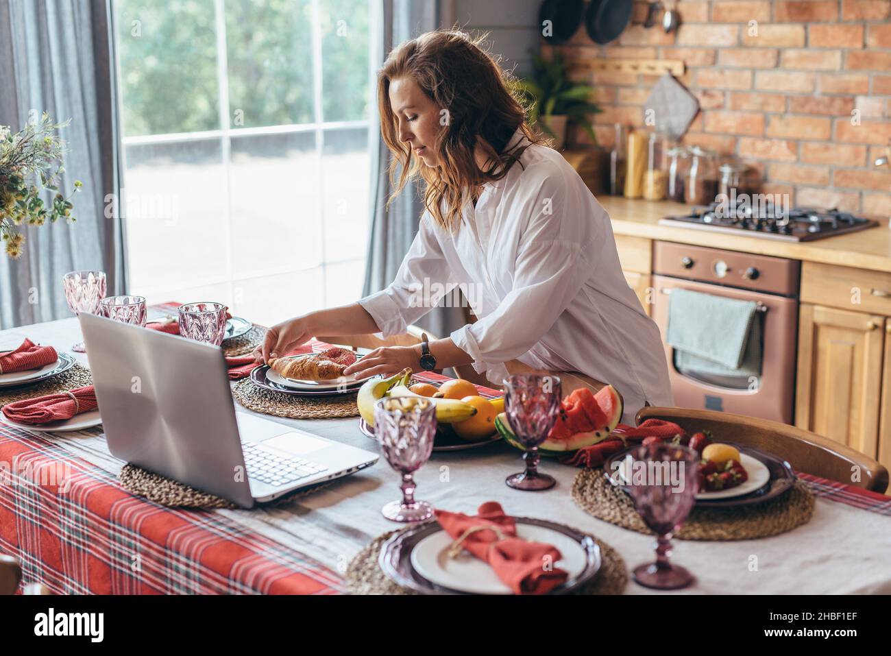 Woman serving the table in the kitchen Stock Photo - Alamy