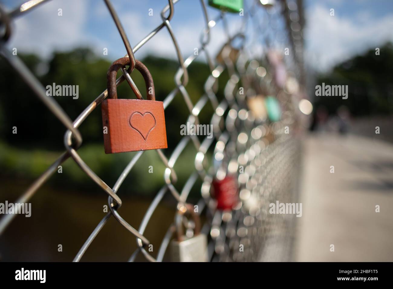 detail of rusty locks with a heart symbol on a fence symbolizing ...
