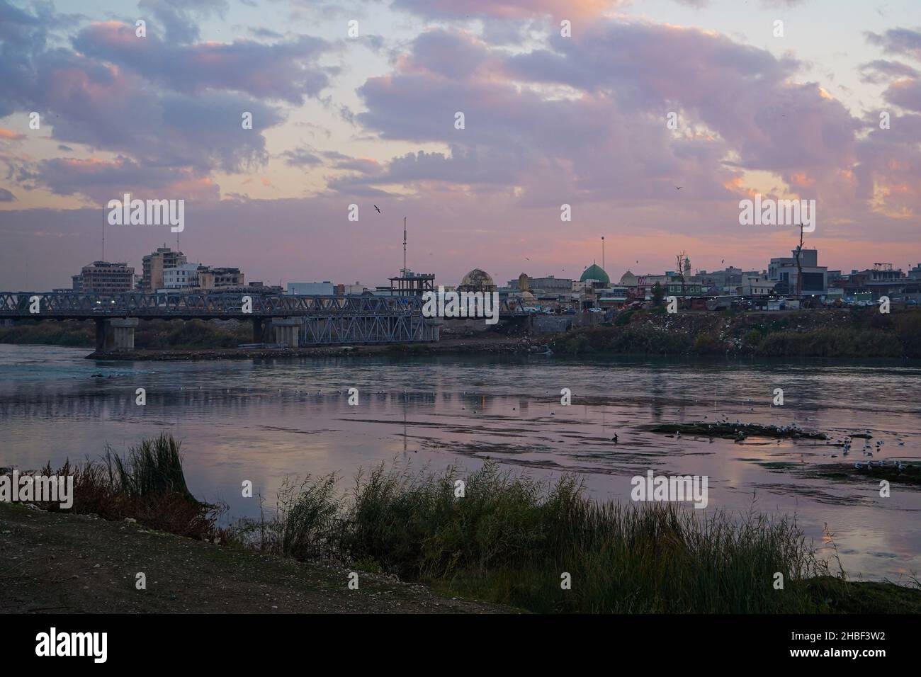 Sunset behind the old bridge over Tigris River in the northern Iraqi ...