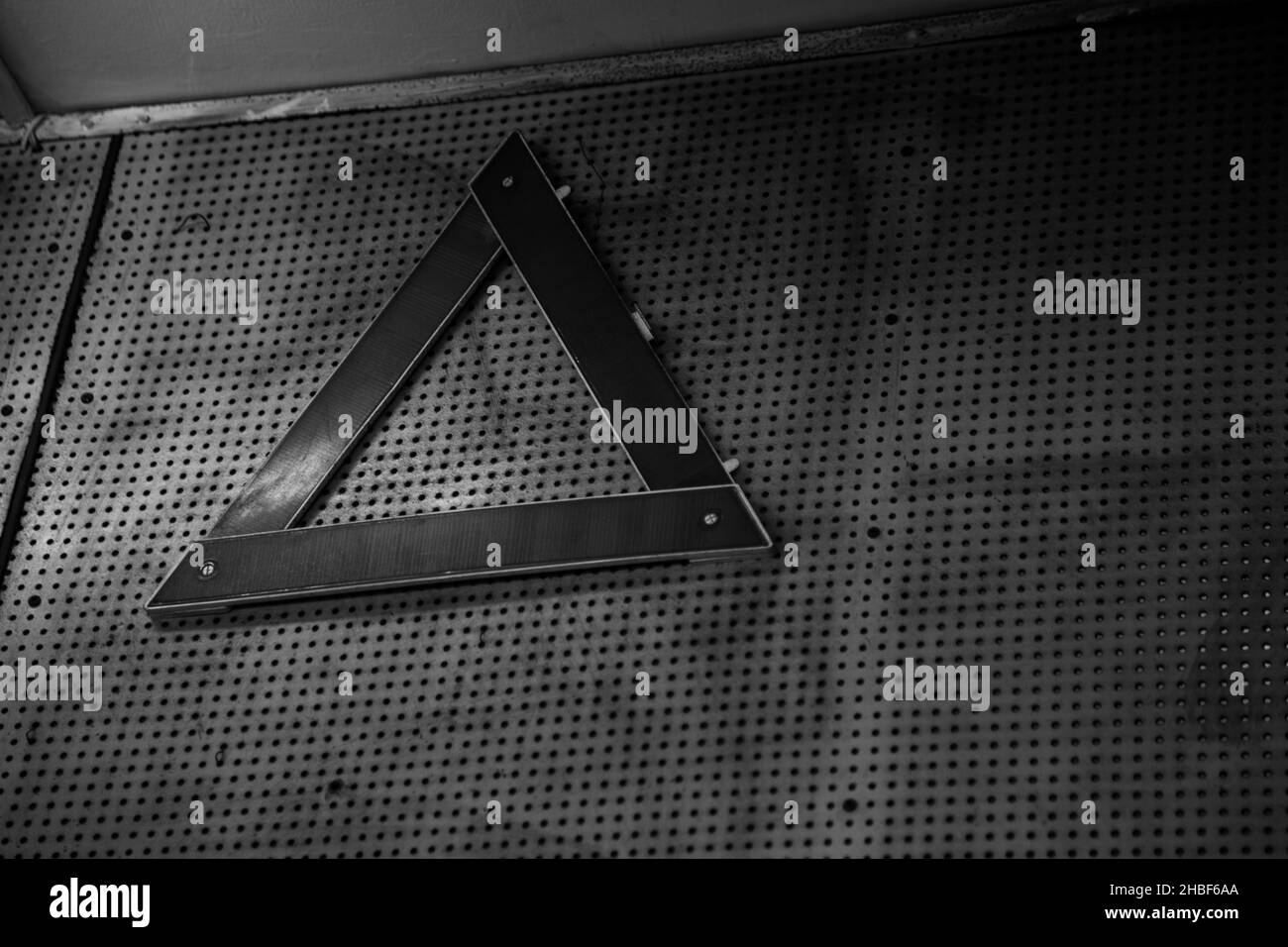 A grayscale of a warning triangle on a wall Stock Photo - Alamy