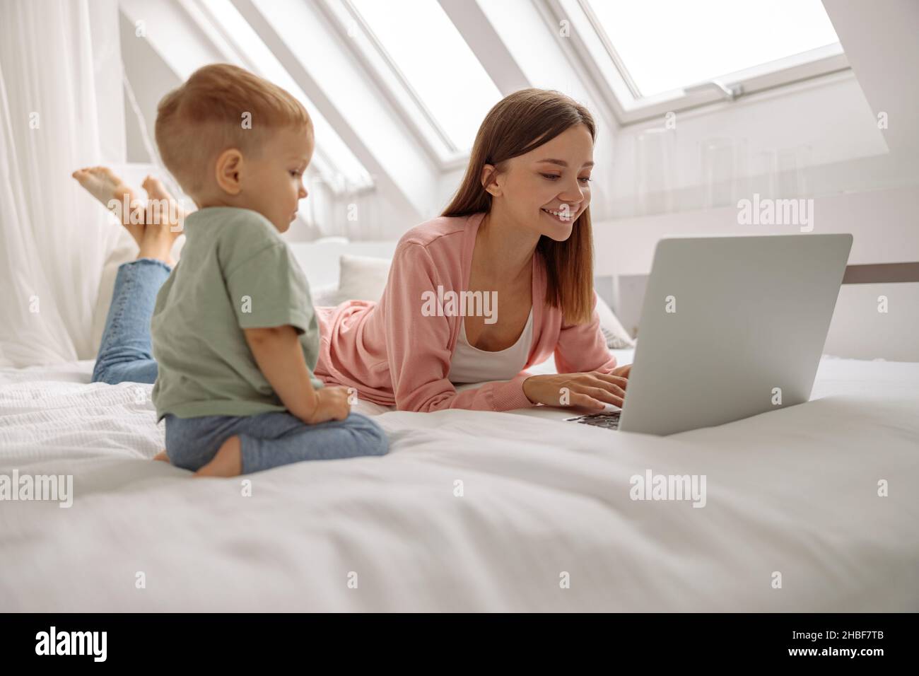 Happy lady using laptop while looking at screen Stock Photo - Alamy