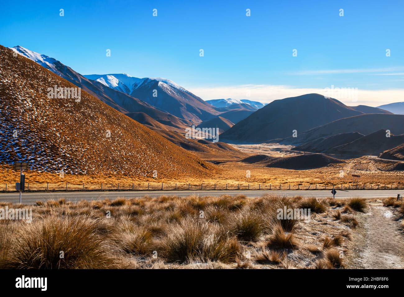 Driving through the golden tussock terrain of the Alpine Pass with a ...