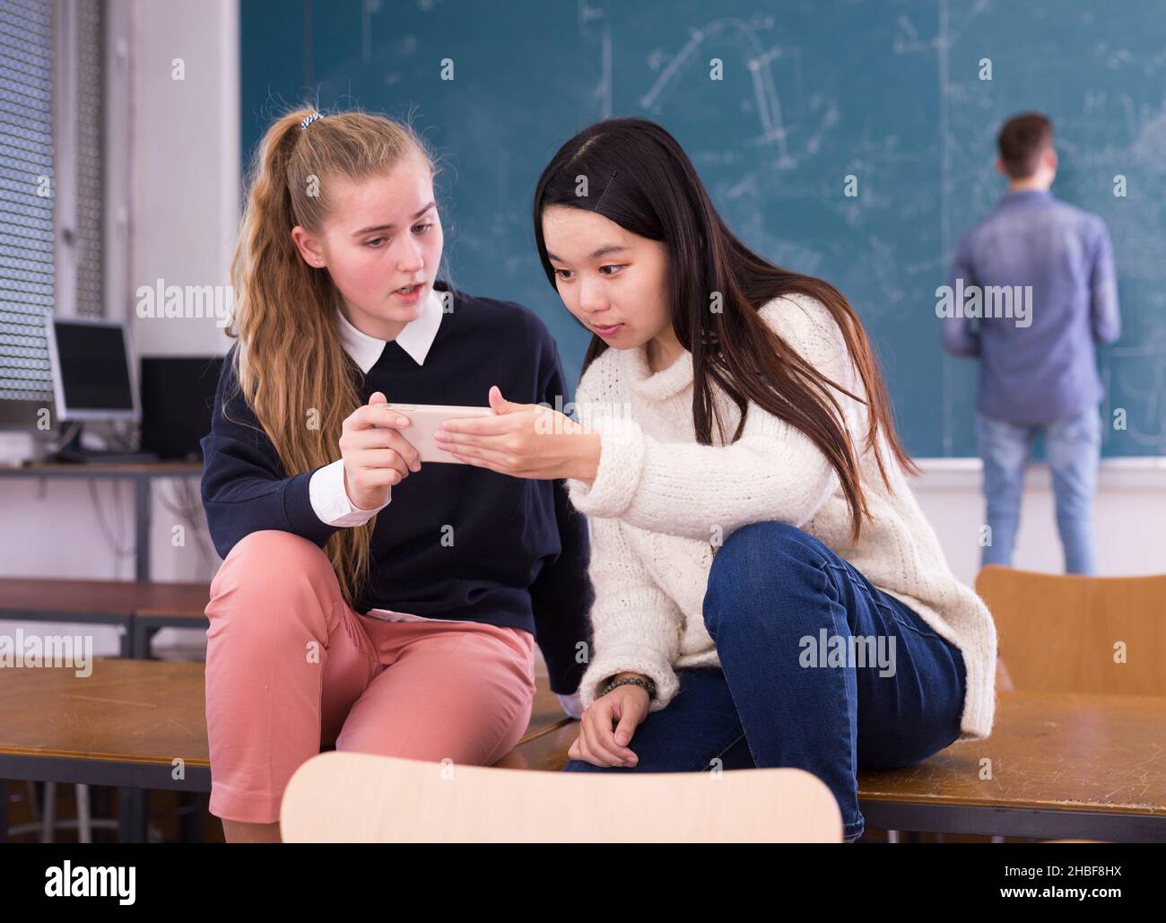Girls students using smartphone during break in auditorium Stock Photo ...