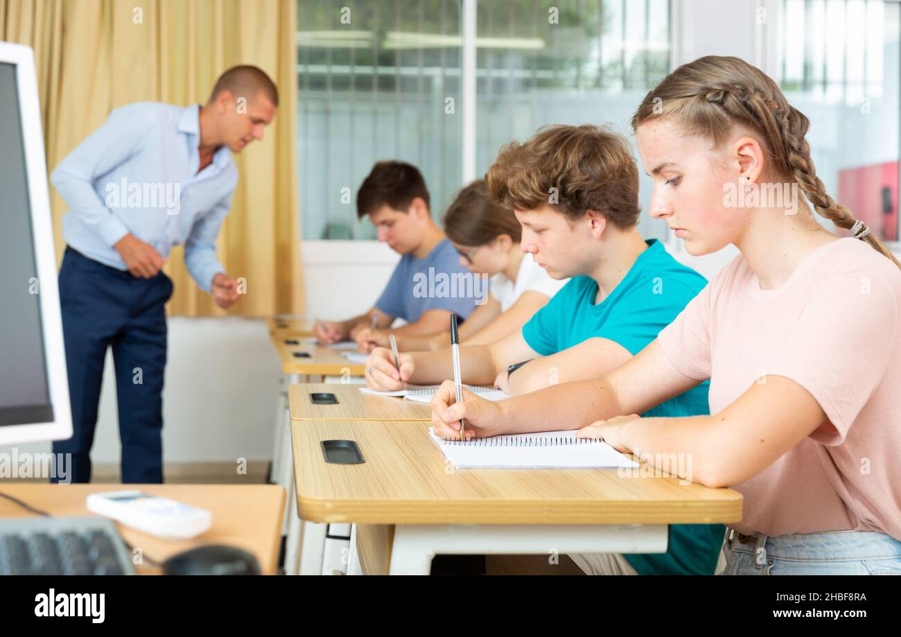Teenage schoolgirl writing lectures in classroom during lesson Stock ...