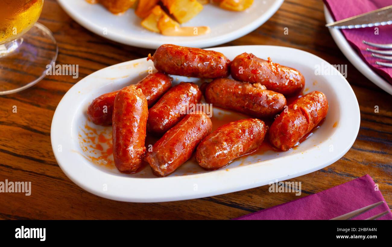 Spanish mini chorizo sausages at plate on table Stock Photo - Alamy