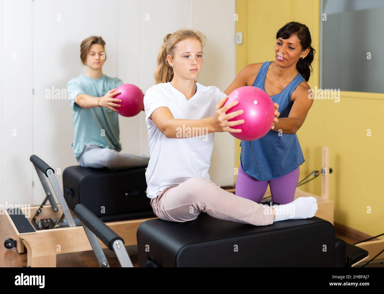 Pilates instructor shows girl how to exercise with ball Stock Photo - Alamy