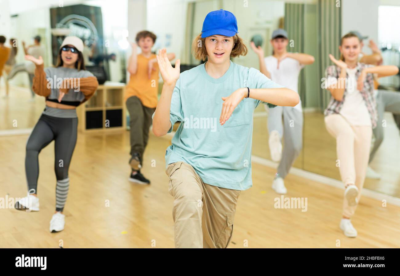 Teenage boy practicing hip-hop movements with group in studio Stock ...