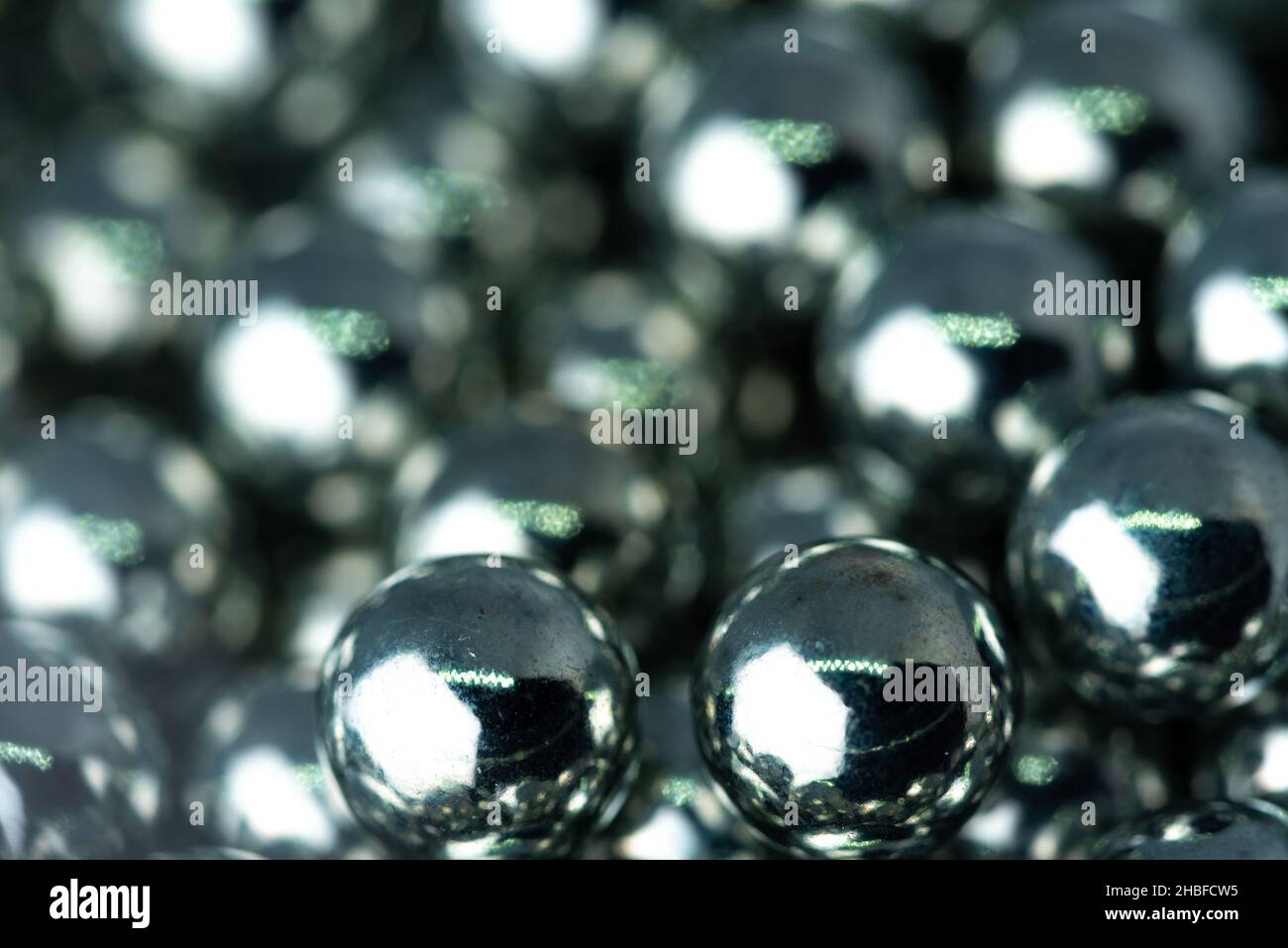 Metal balls arranged side by side to form an organized structure. Macro ...