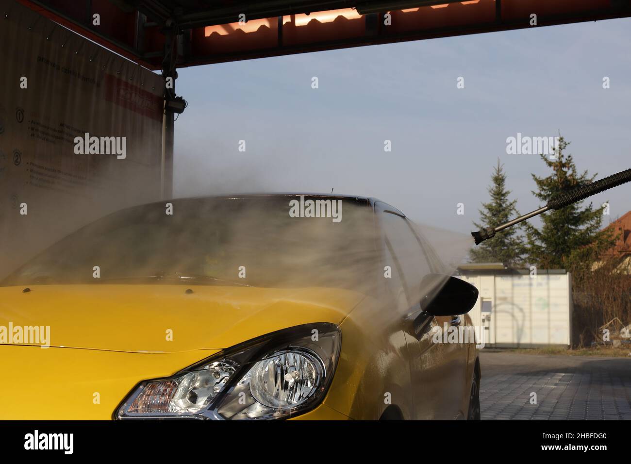 A person washing a yellow car in a car wash Stock Photo - Alamy