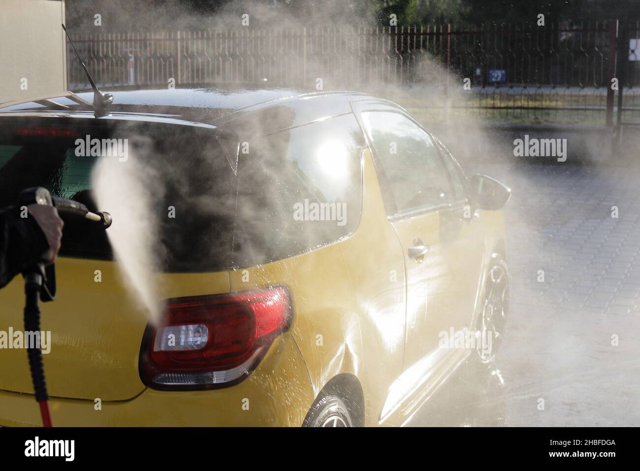 A hand of a man washing a yellow car in a car wash Stock Photo - Alamy