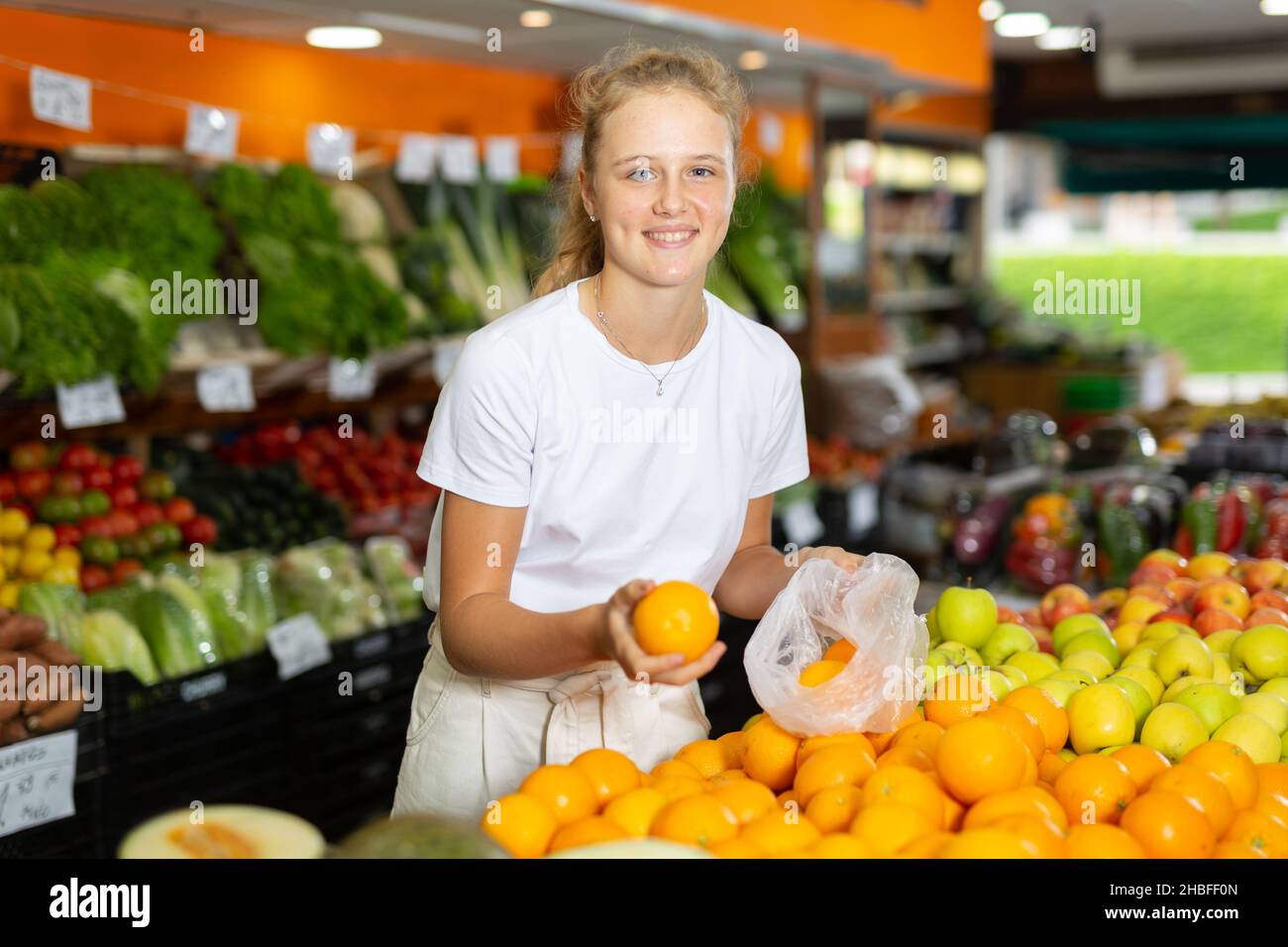 Girl consumer choosing oranges at supermarket Stock Photo - Alamy
