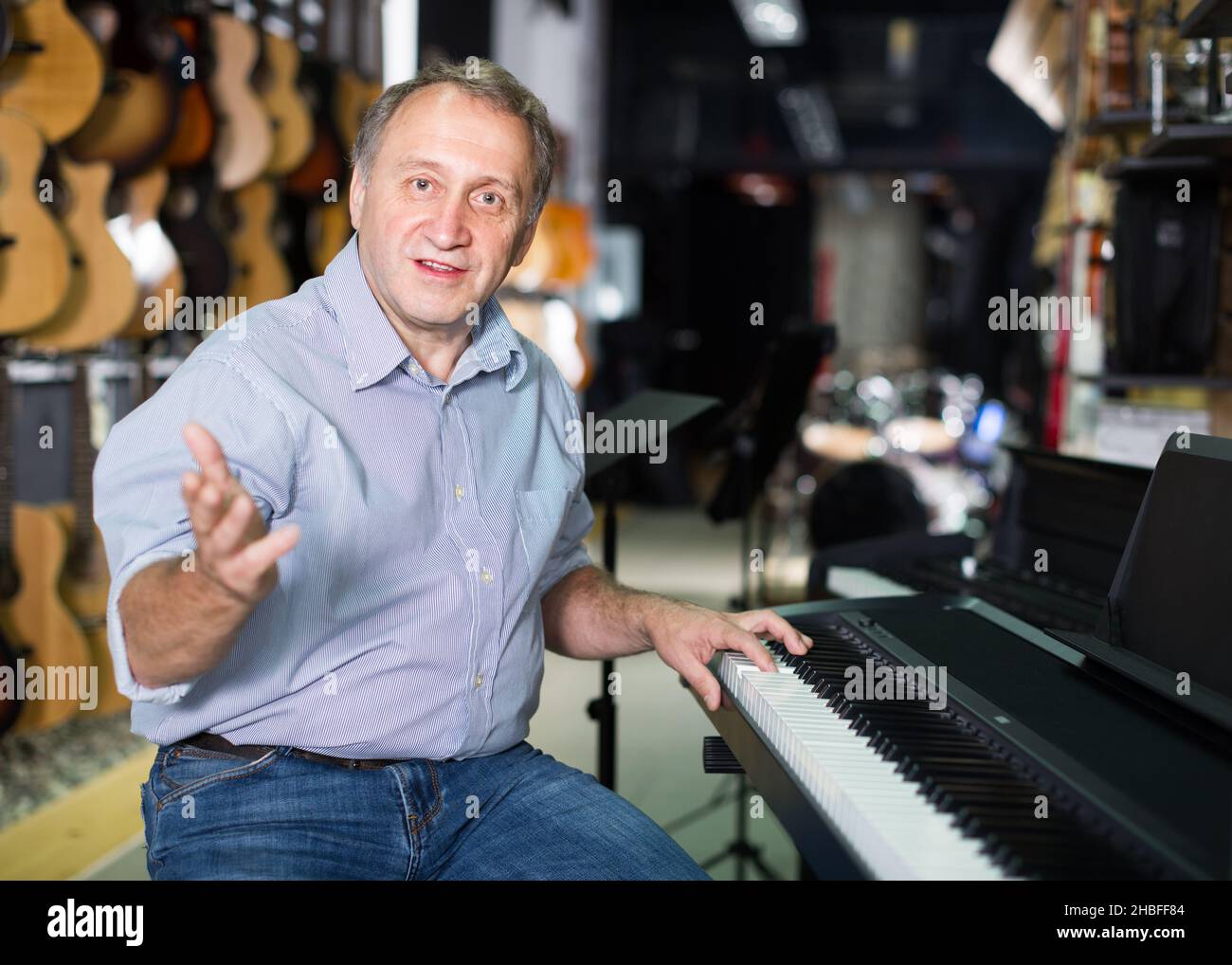Musician male is choosing keyboard and playing on it Stock Photo - Alamy