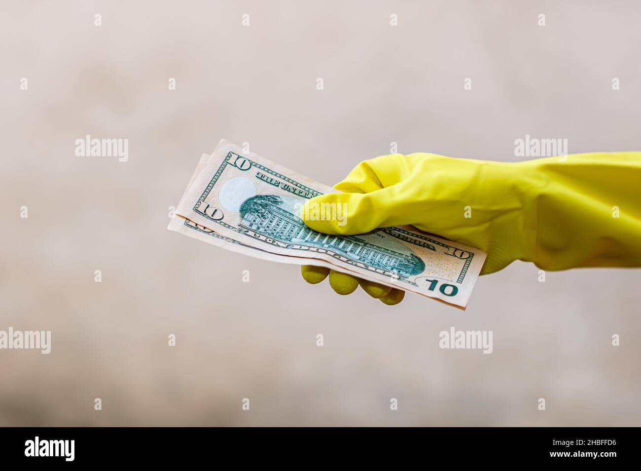 A hand with rubber gloves holding 10 USD banknote Stock Photo - Alamy