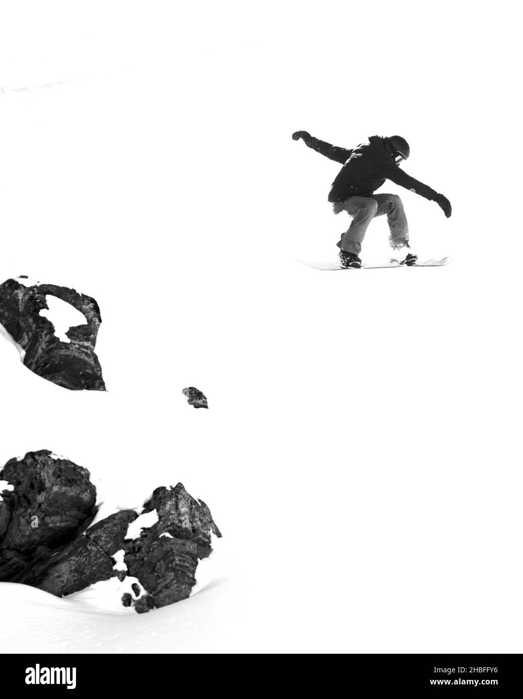 A vertical shot of a snowboarder jumping off a cliff Stock Photo - Alamy