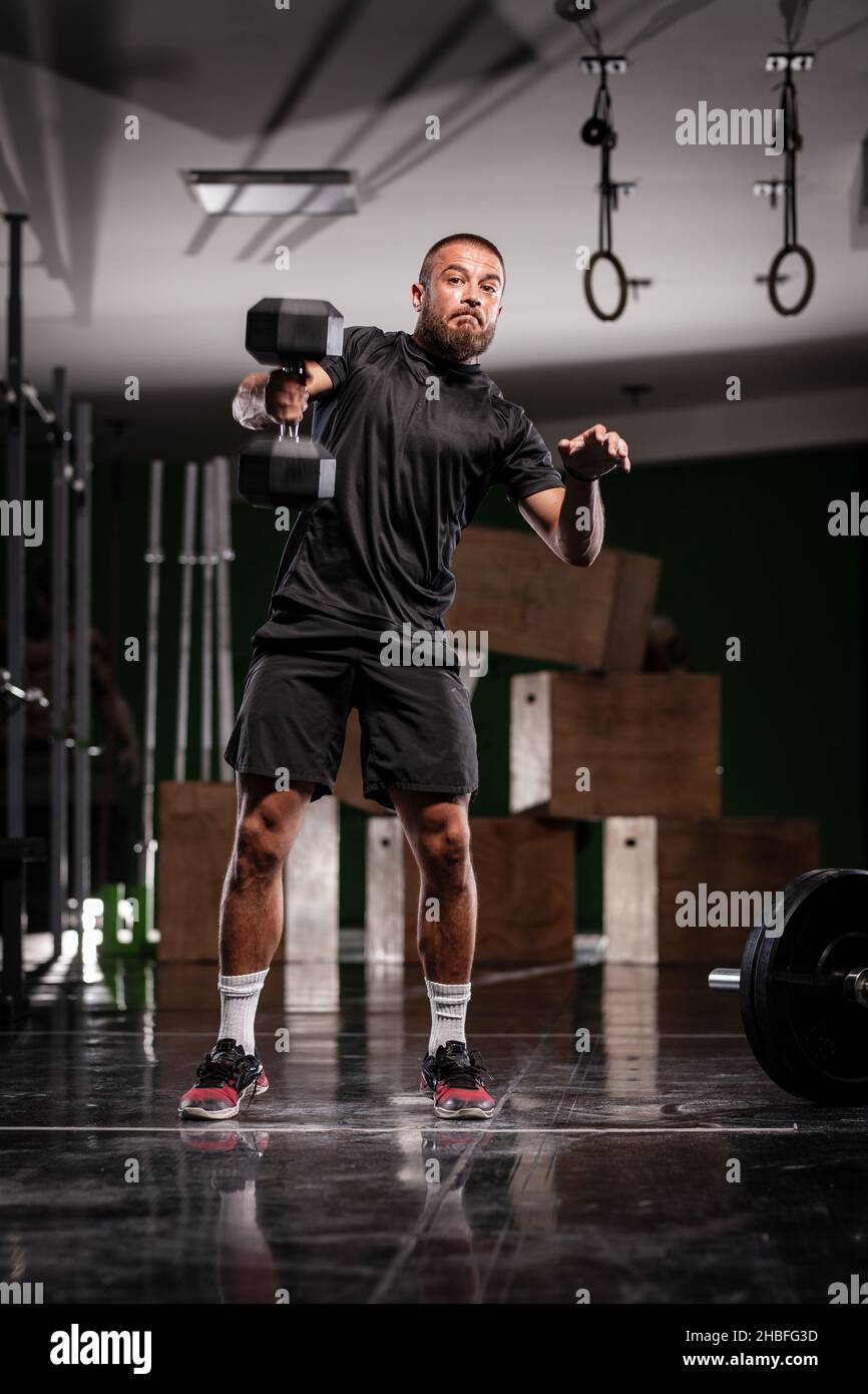 Muscular athlete lifting very heavy weights. Man working out indoors ...