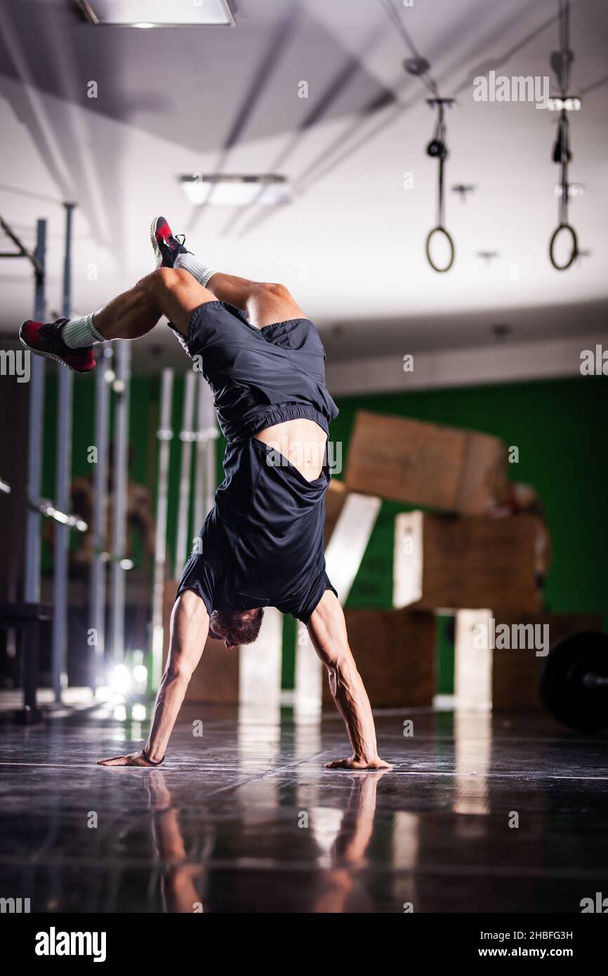 Muscular athlete standing and walking on hands upside down Stock Photo ...