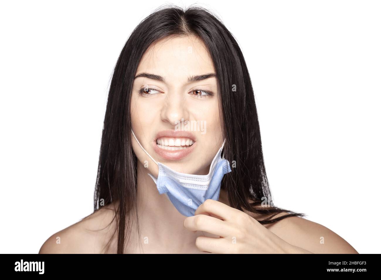 Angry girl pulling away medical face mask. Portrait against white ...