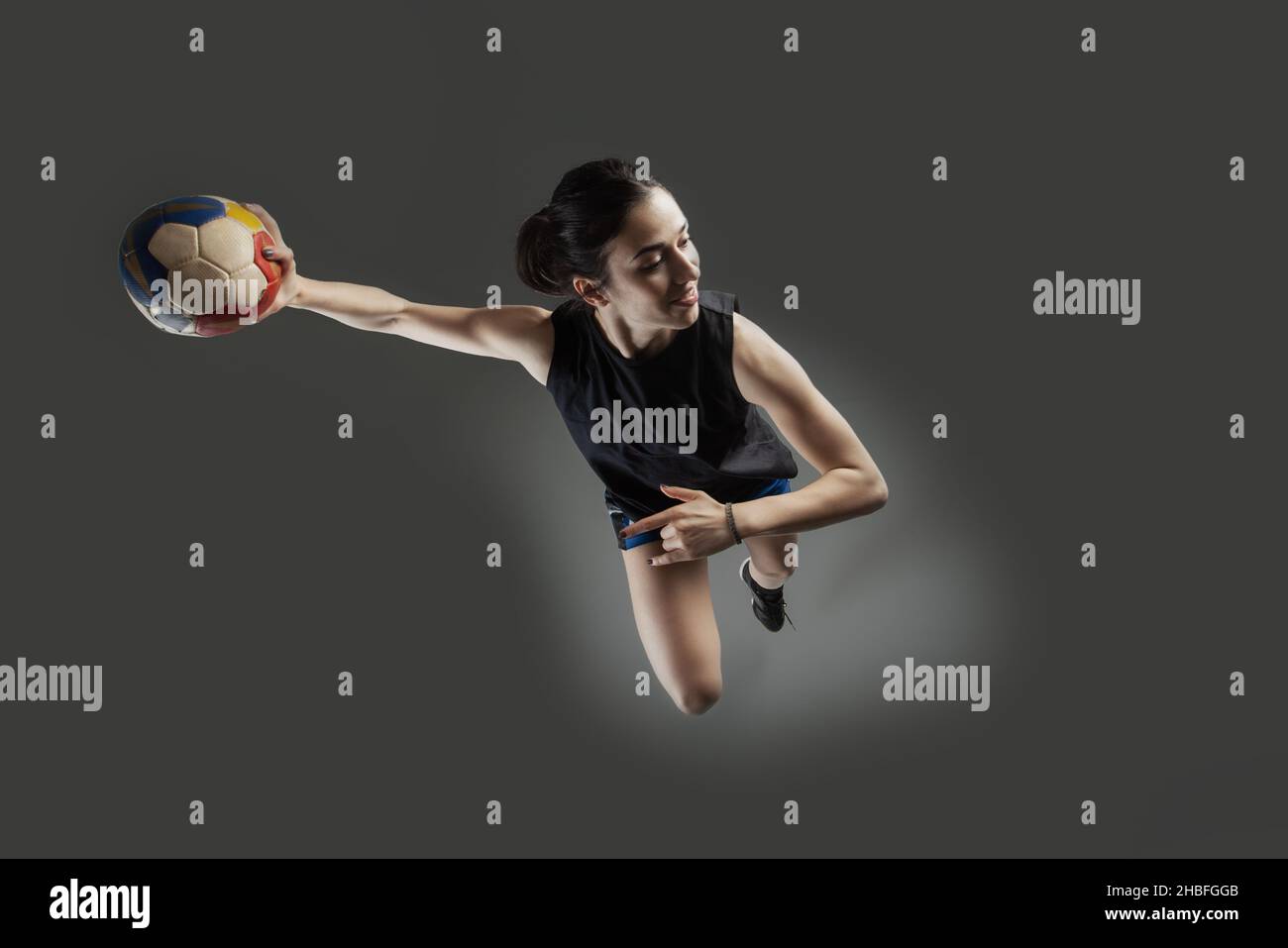 Handball player posing on gray background. Girl jumping with ball Stock ...