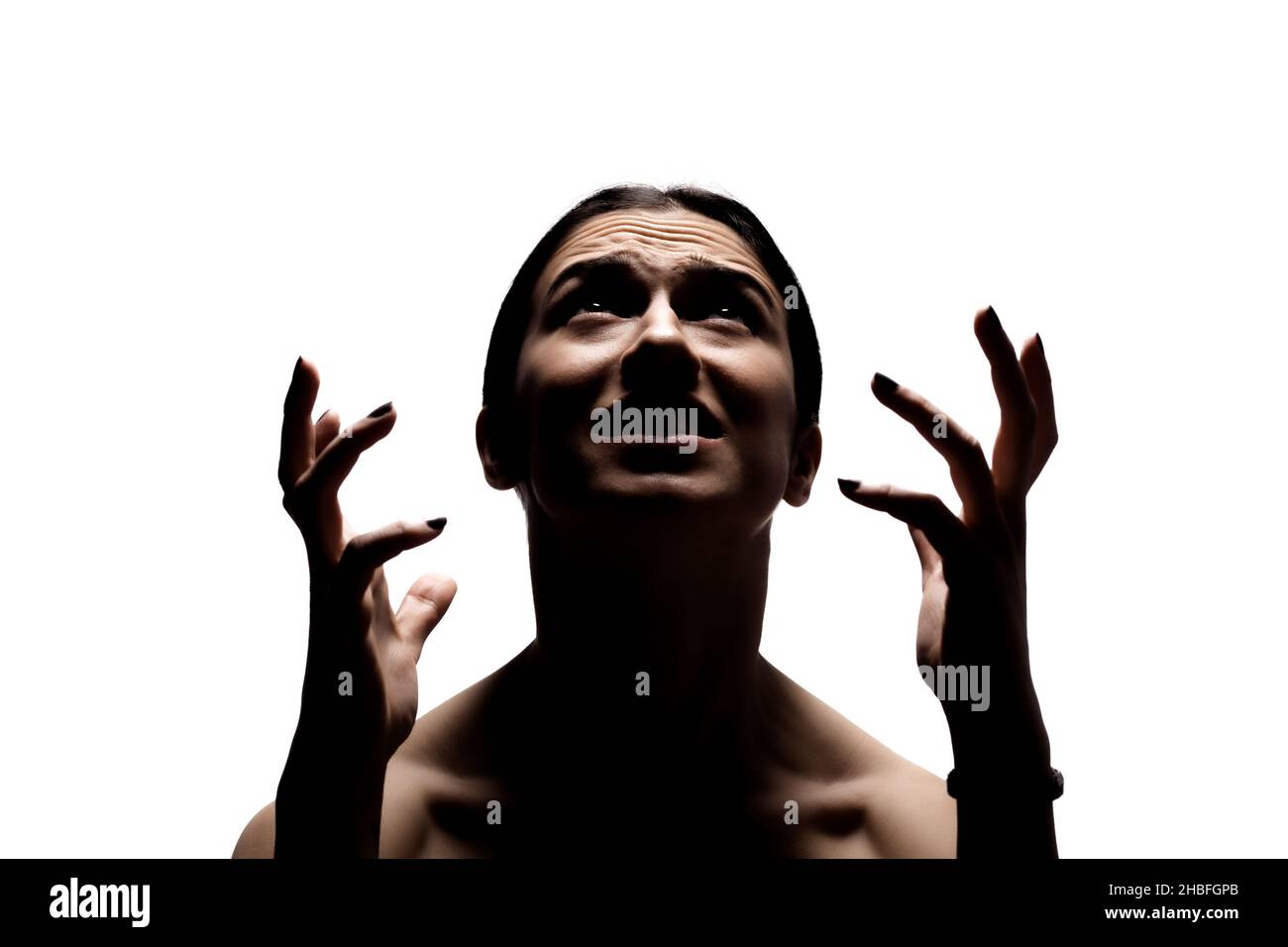 Dark half silhouette portrait with shadows of an angry girl looking up ...