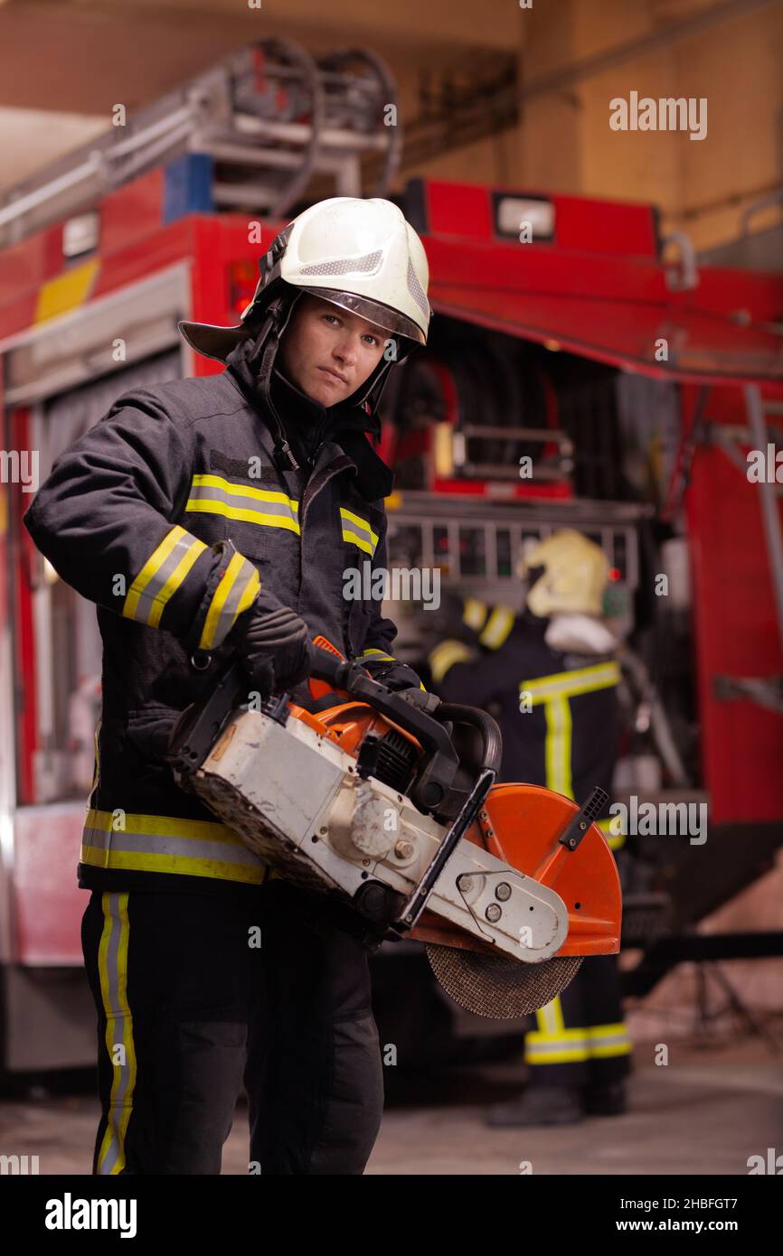 Professional firefighter in uniform wearing protective helmet and ...