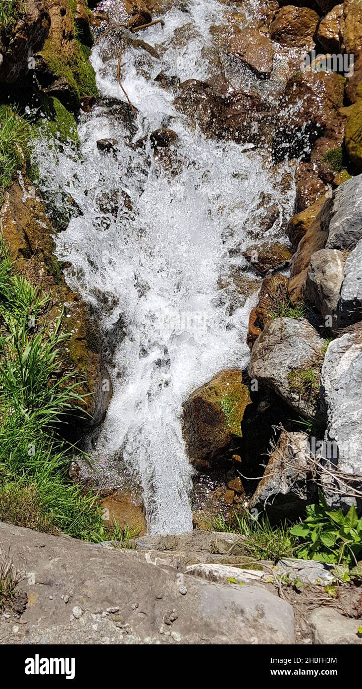 A top view of a waterfall falling on the mossy rocks in the forest in ...