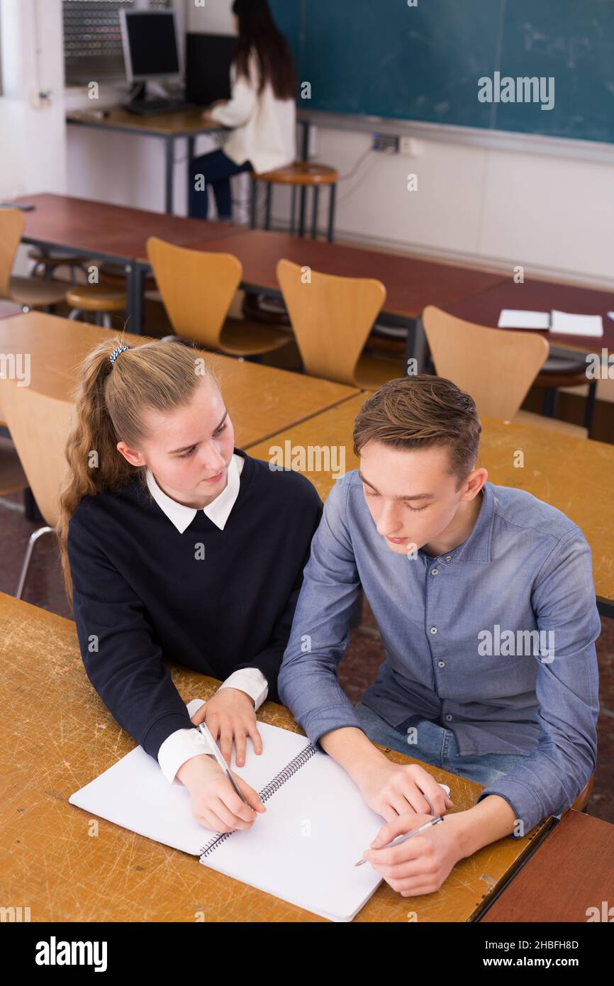 Girl student explaining study material to classmate Stock Photo - Alamy