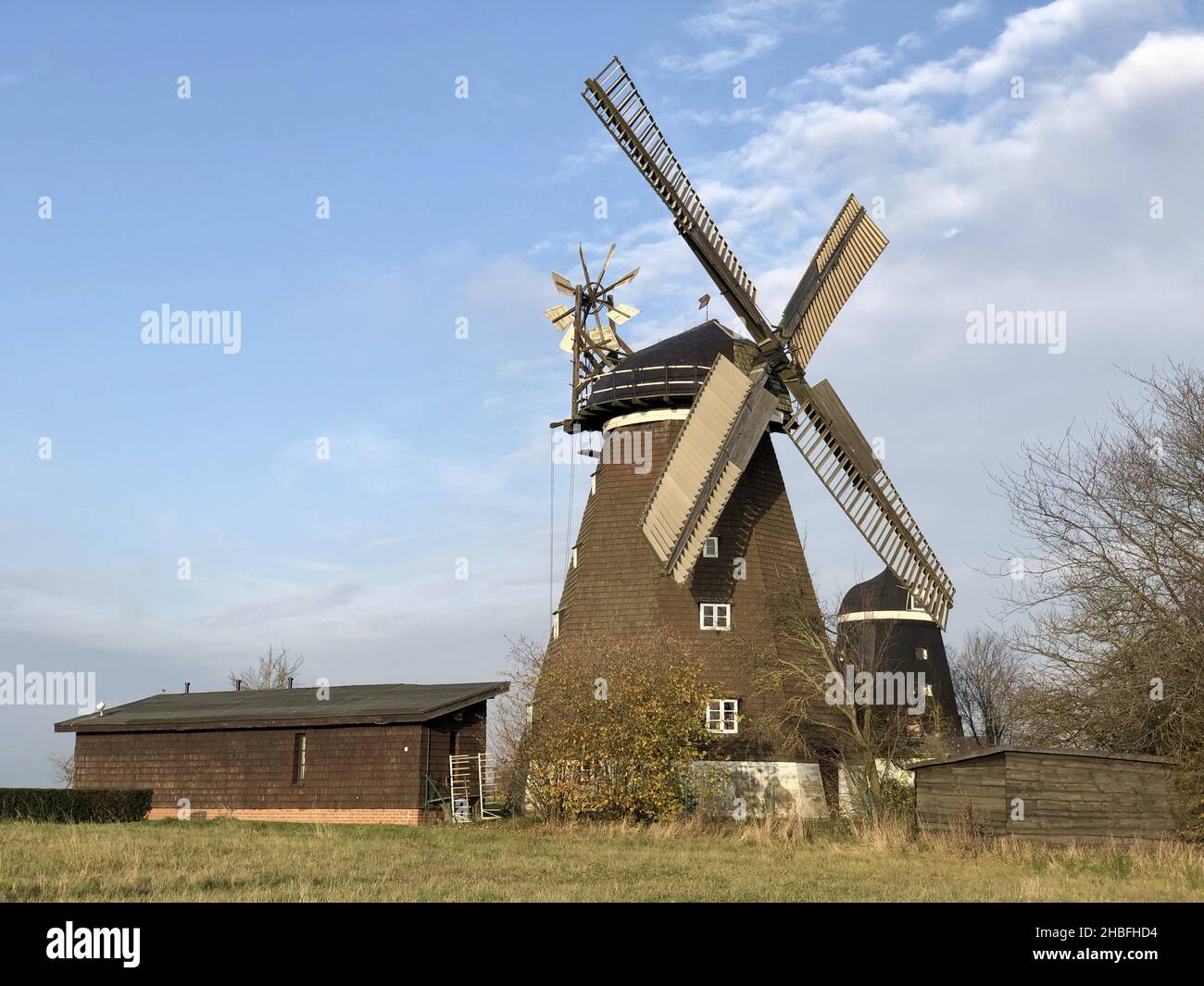 A bright summer day in the countryside with a big windmill in the open ...