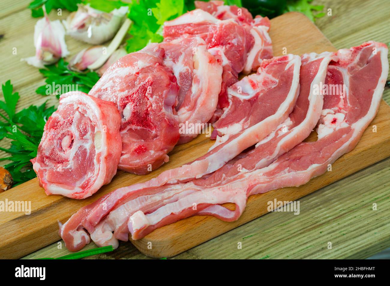 Fresh slices of mutton and vegetables assortment on natural wooden desk ...