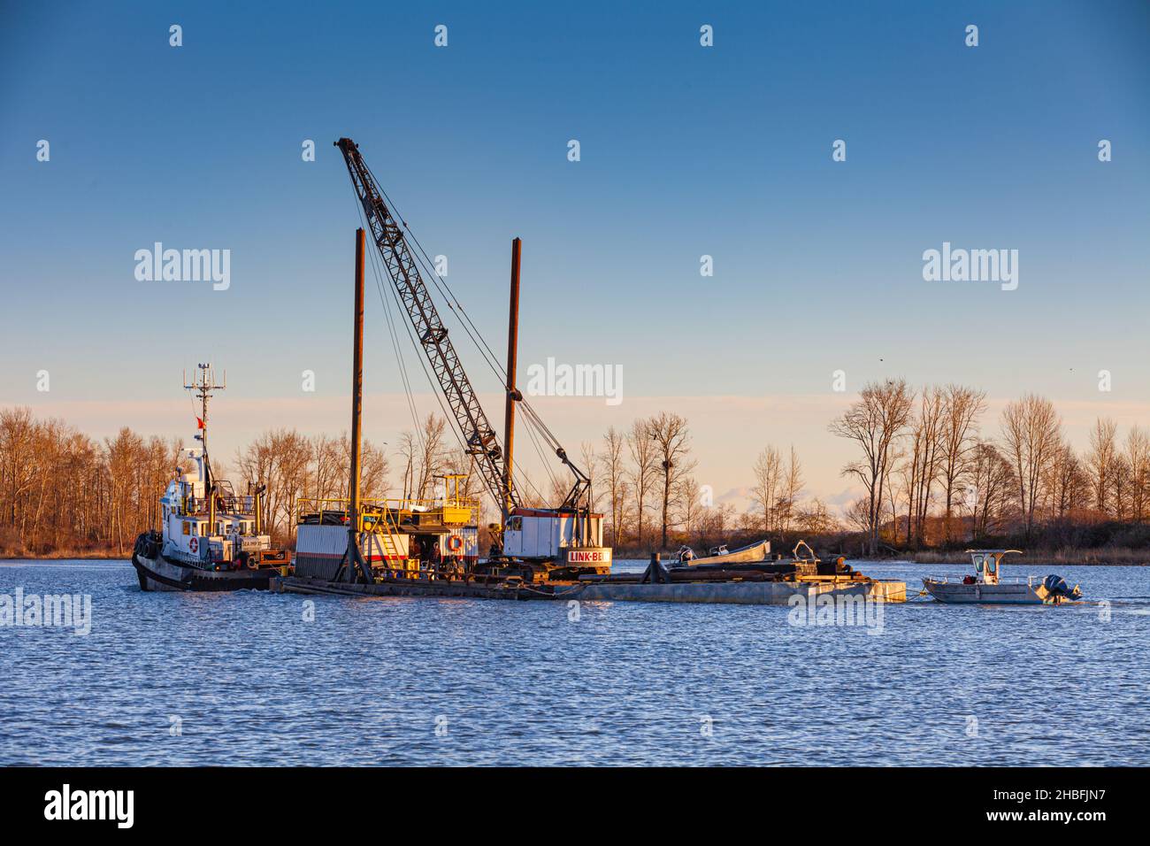 Tugboat towing a dredging crane and barge in the Steveston Inlet ...
