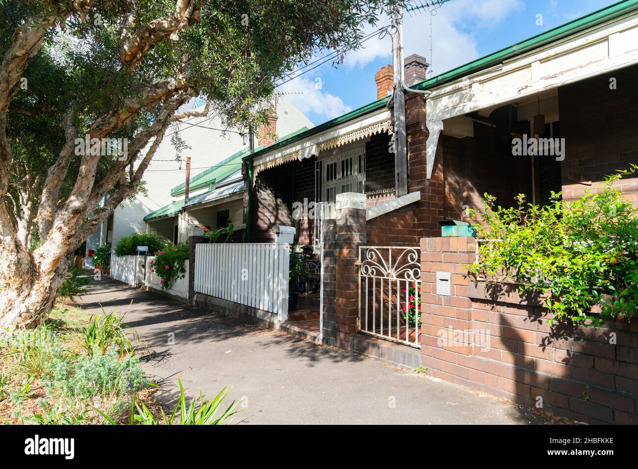 Footpath leading past row colonial style houses in leafy residential ...