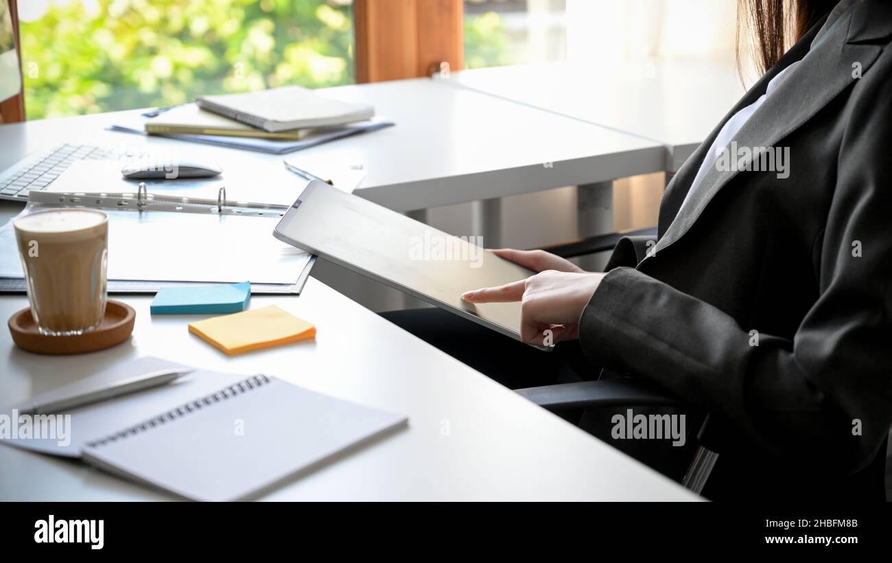 Cropped image of a successful female manager in black suit using ...