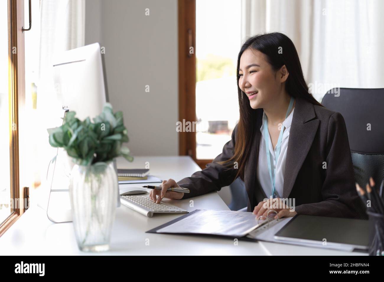 Young asian finance market analyst working at the office on desktop ...