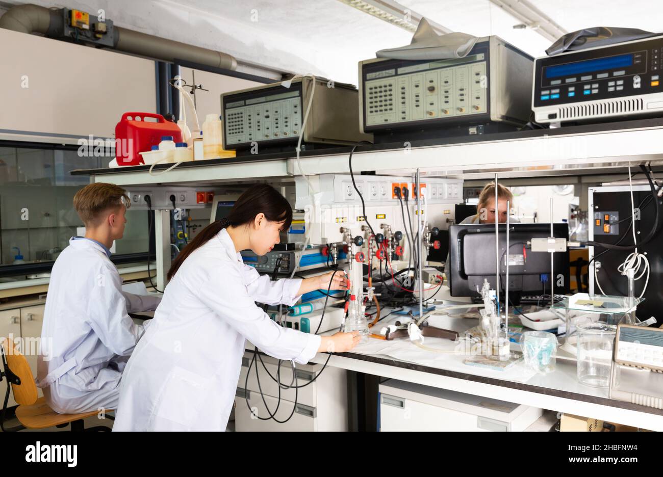 international group of scientists using lab equipment during research ...