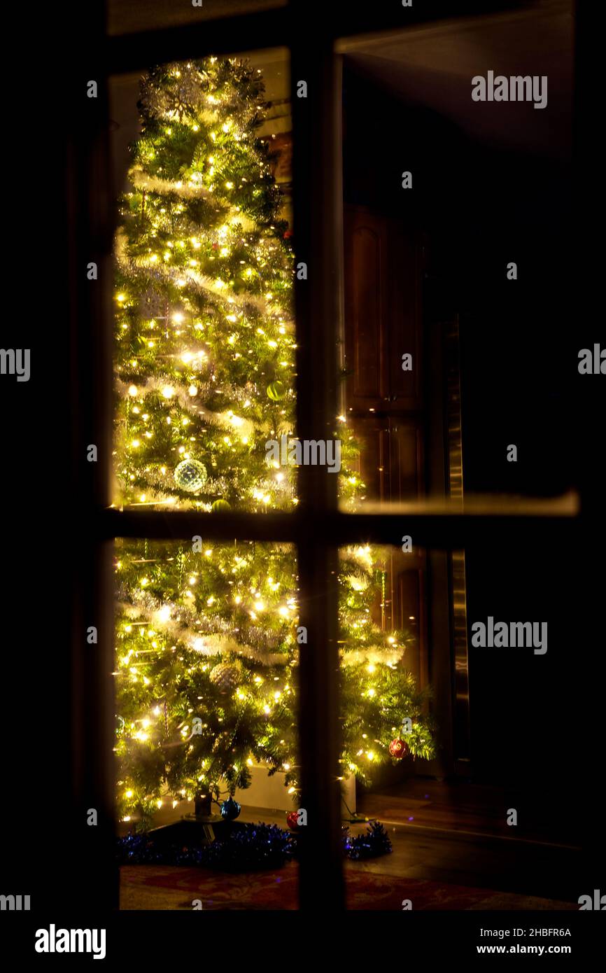 Christmas tree with white defocused lights through a window Stock Photo ...
