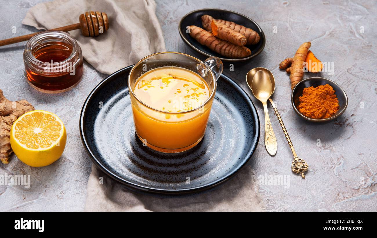 Healthy turmeric golden tea on light gray background. Indian ...