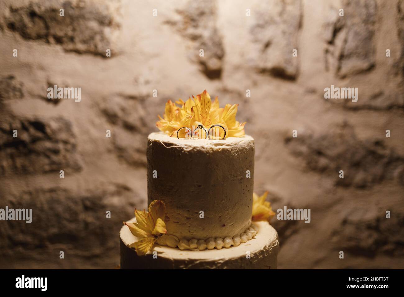 White wedding cake on a stone wall background Stock Photo - Alamy